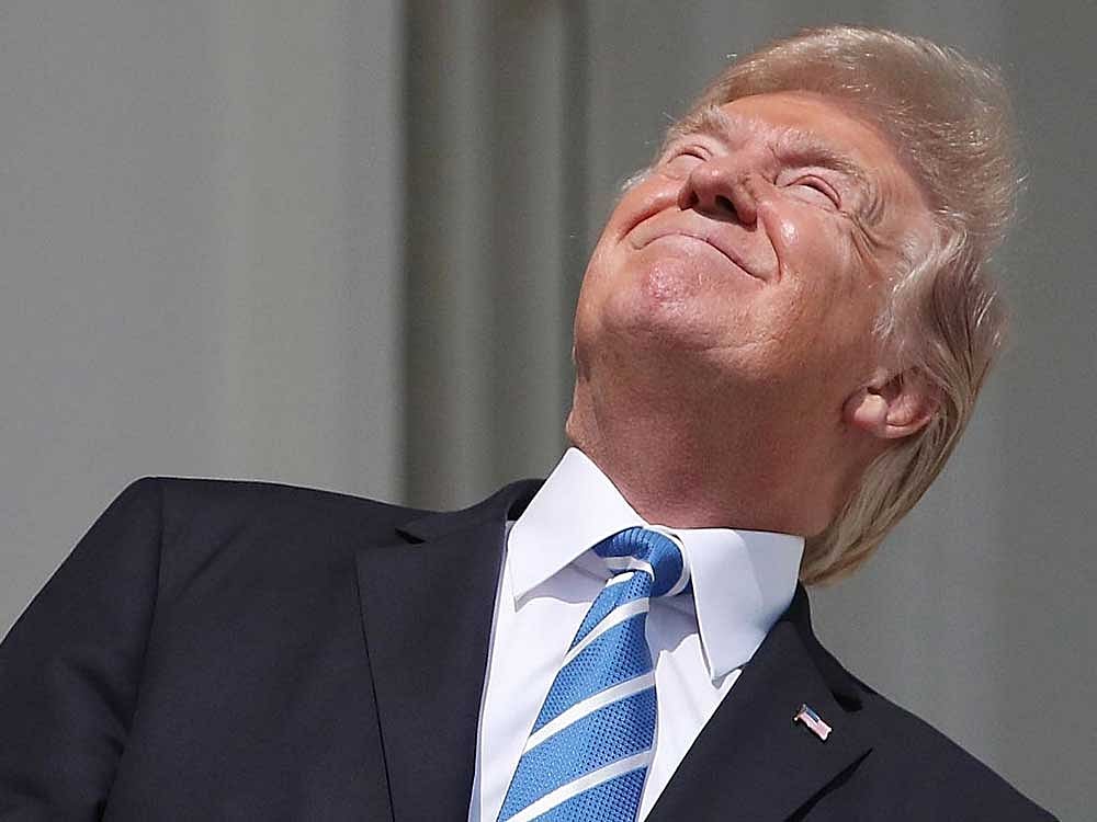 Donald Trump does the unthinkable: staring at the Sun, during an eclipse